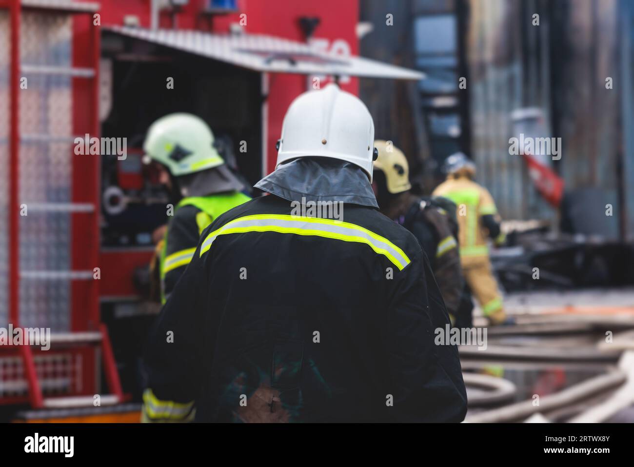 Group of fire men in protective uniform during fire fighting operation ...