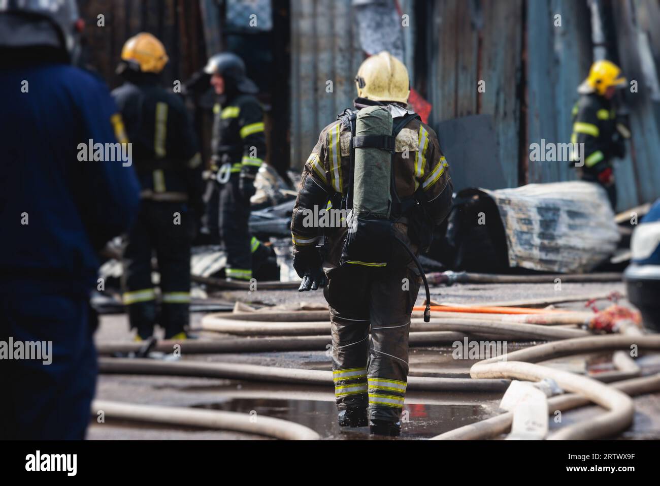 Group of fire men in protective uniform during fire fighting operation ...