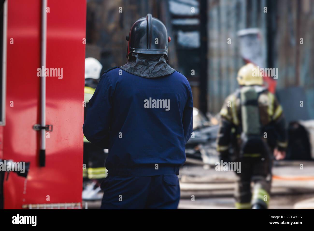Group of fire men in protective uniform during fire fighting operation ...