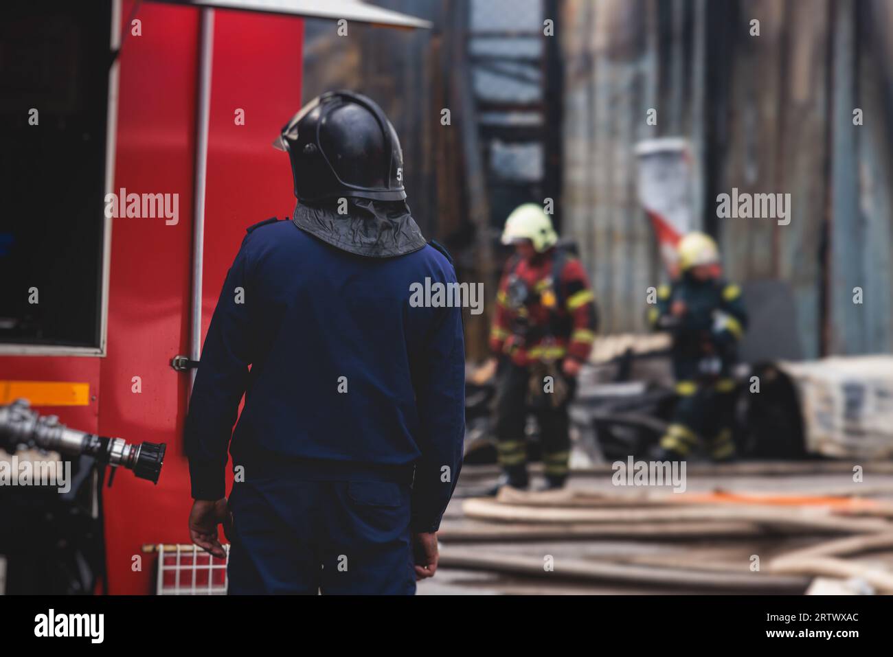 Group of fire men in protective uniform during fire fighting operation ...