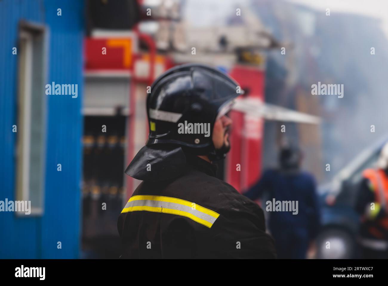 Group of fire men in protective uniform during fire fighting operation ...