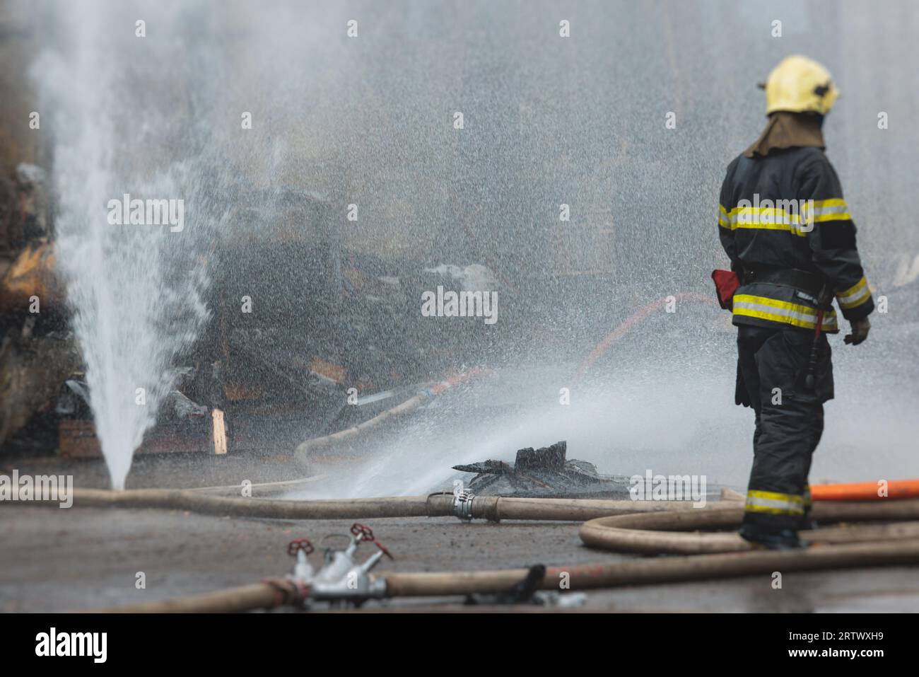 Group of fire men in protective uniform during fire fighting operation ...