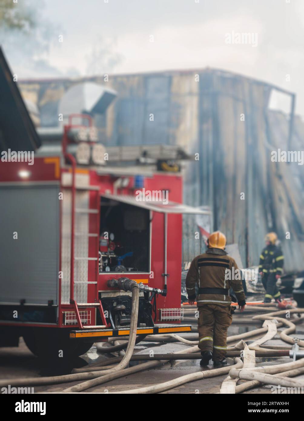 Group of fire men in protective uniform during fire fighting operation ...