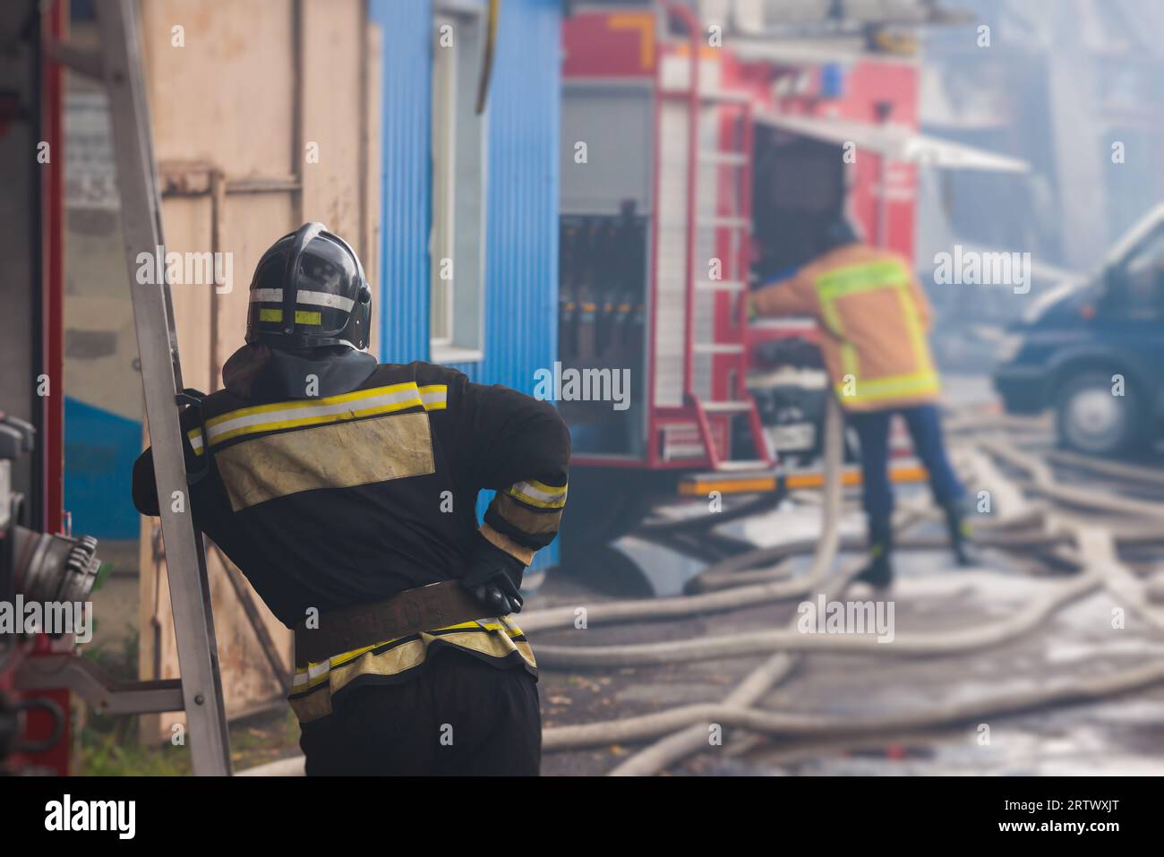 Group of fire men in protective uniform during fire fighting operation ...