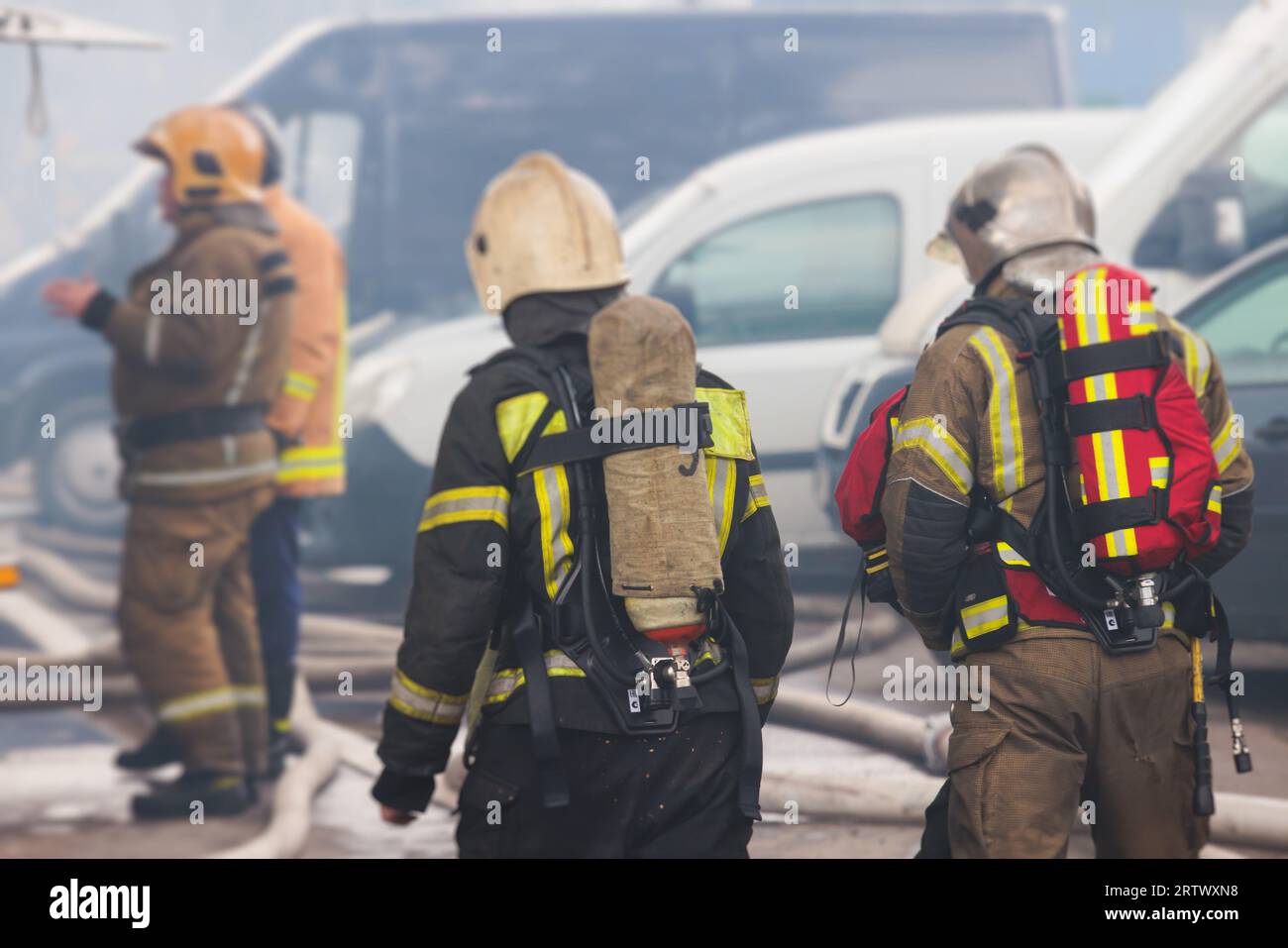 Group of fire men in protective uniform during fire fighting operation ...