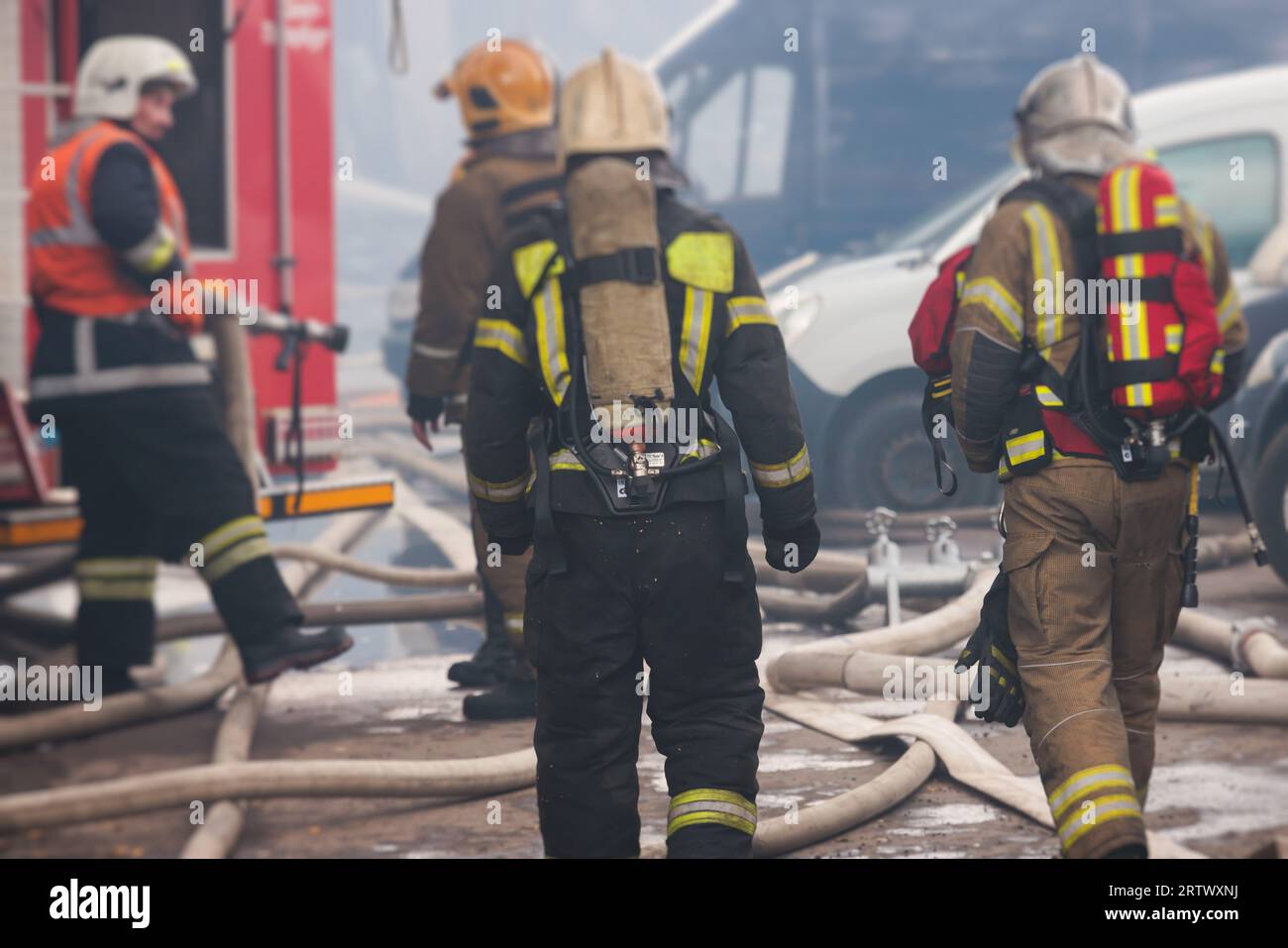 Group of fire men in protective uniform during fire fighting operation ...
