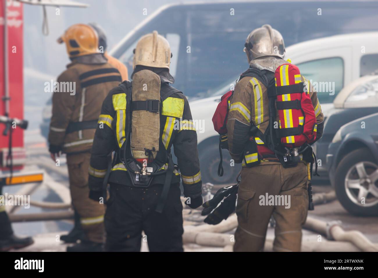 Group of fire men in protective uniform during fire fighting operation ...