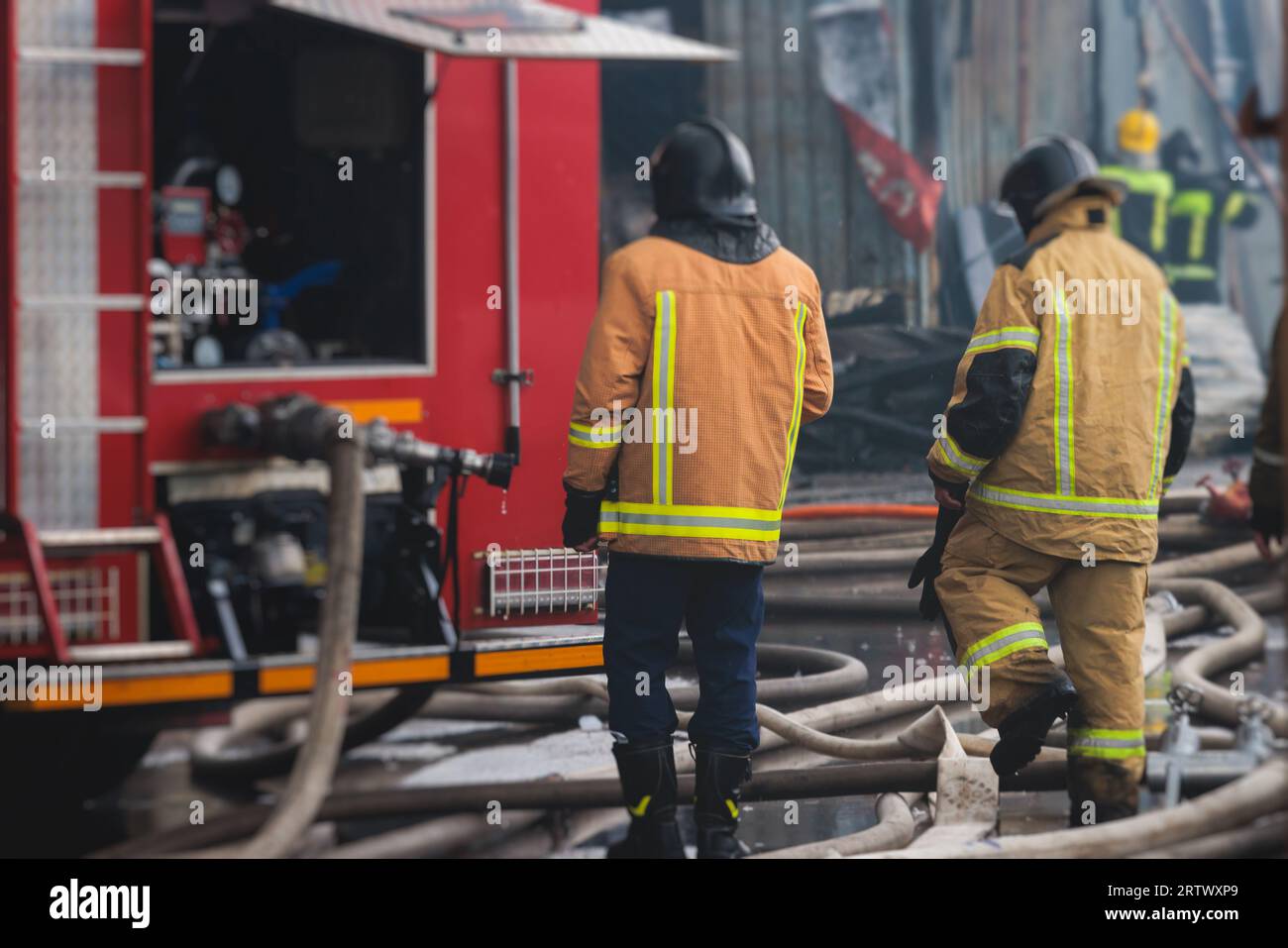 Group of fire men in protective uniform during fire fighting operation ...