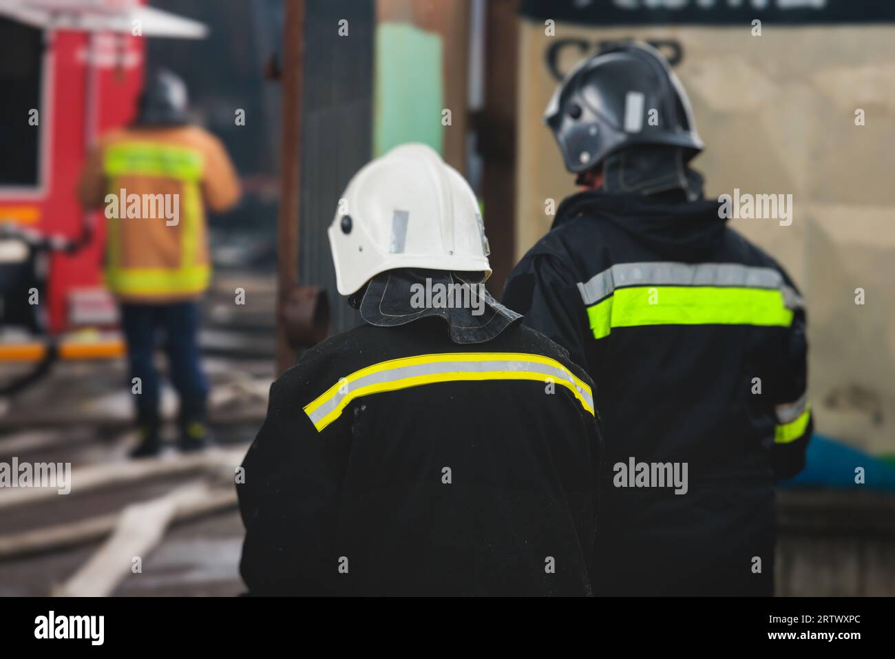 Group of fire men in protective uniform during fire fighting operation ...