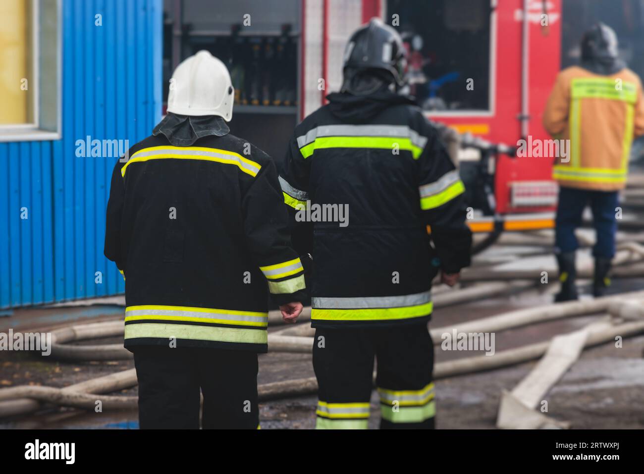 Group of fire men in protective uniform during fire fighting operation ...