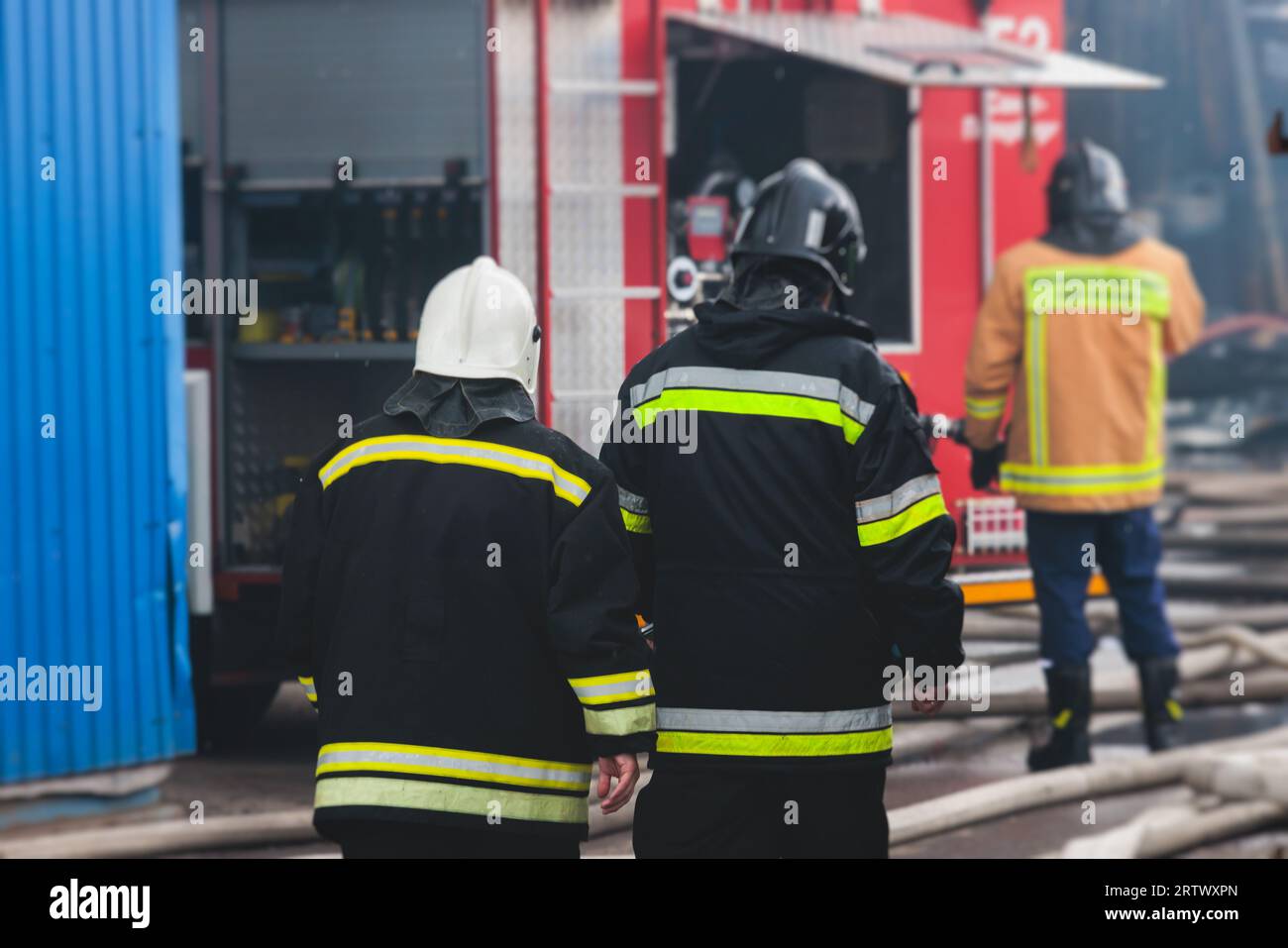 Group of fire men in protective uniform during fire fighting operation ...