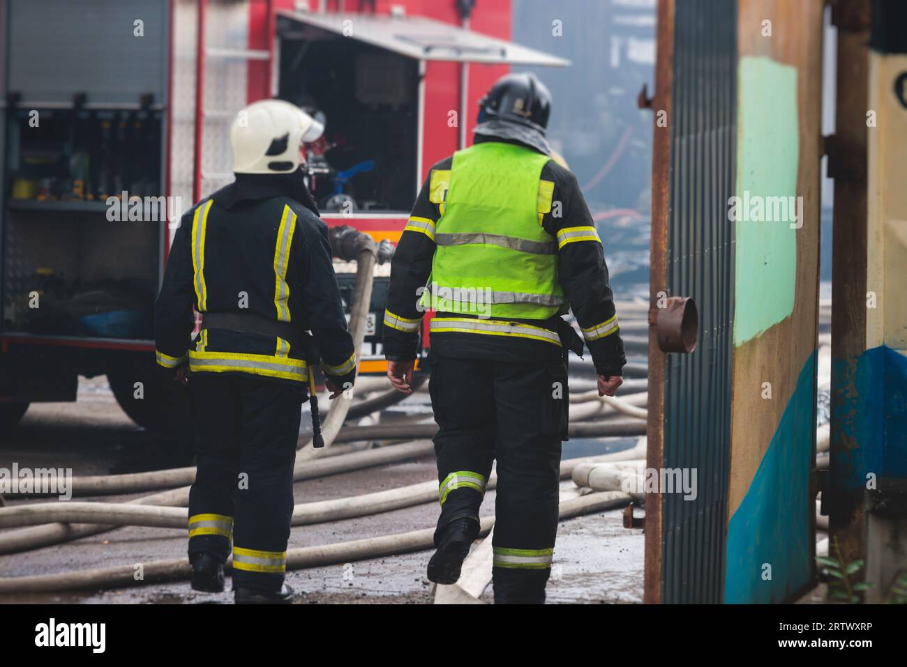 Group of fire men in protective uniform during fire fighting operation ...
