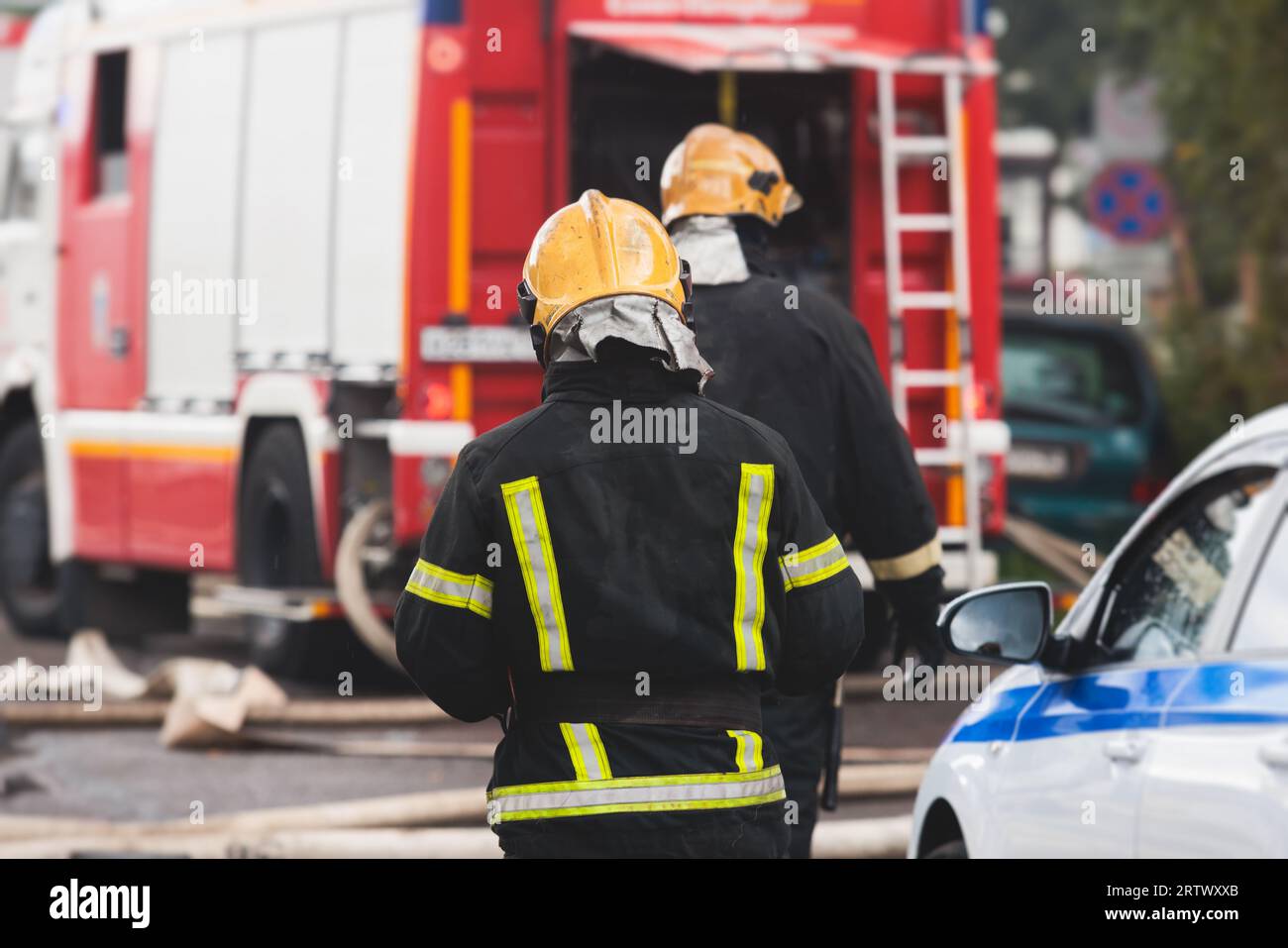 Group of fire men in protective uniform during fire fighting operation ...