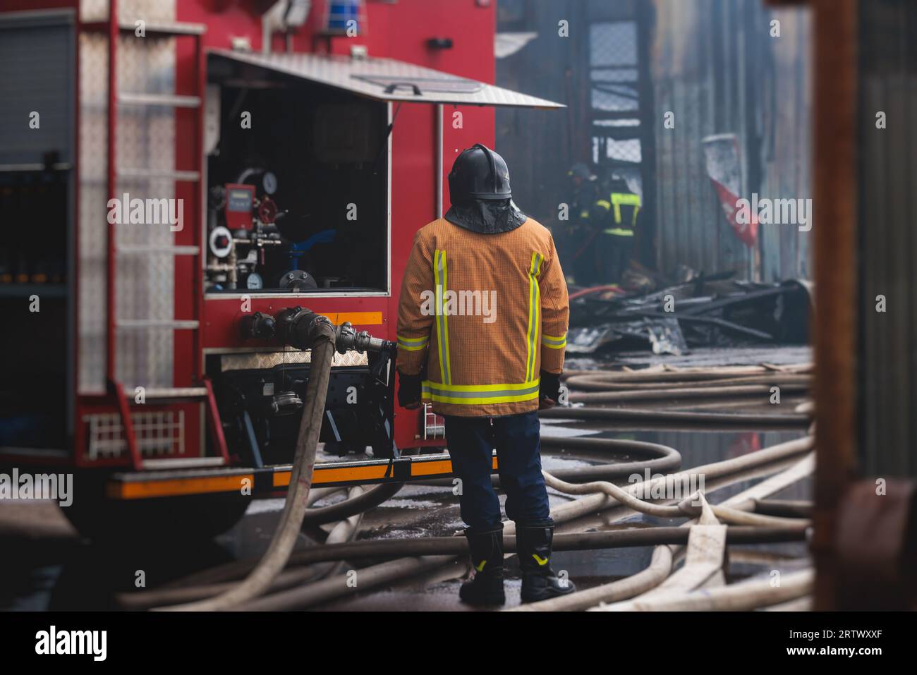 Group of fire men in protective uniform during fire fighting operation ...