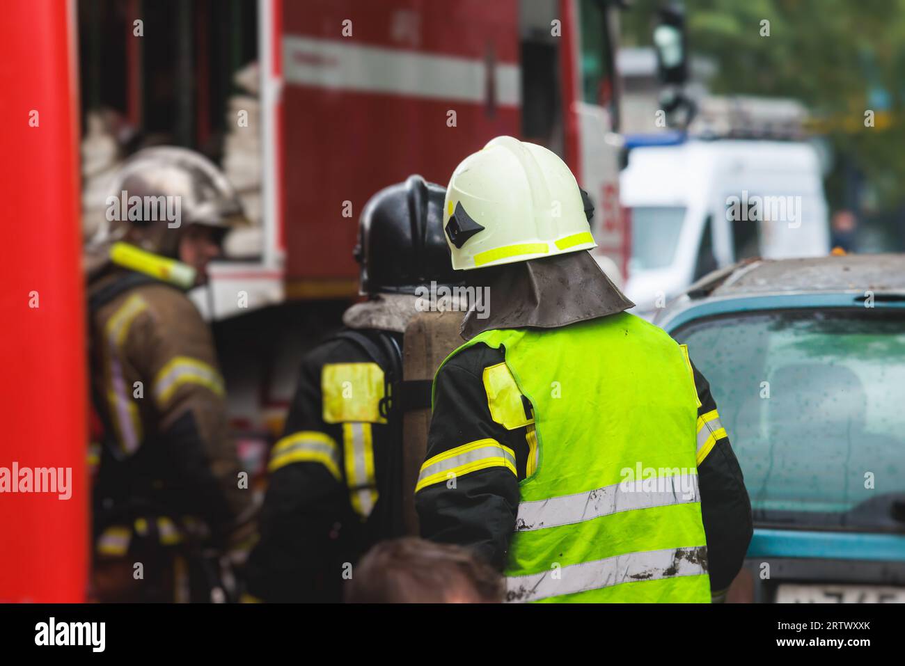 Group of fire men in protective uniform during fire fighting operation ...