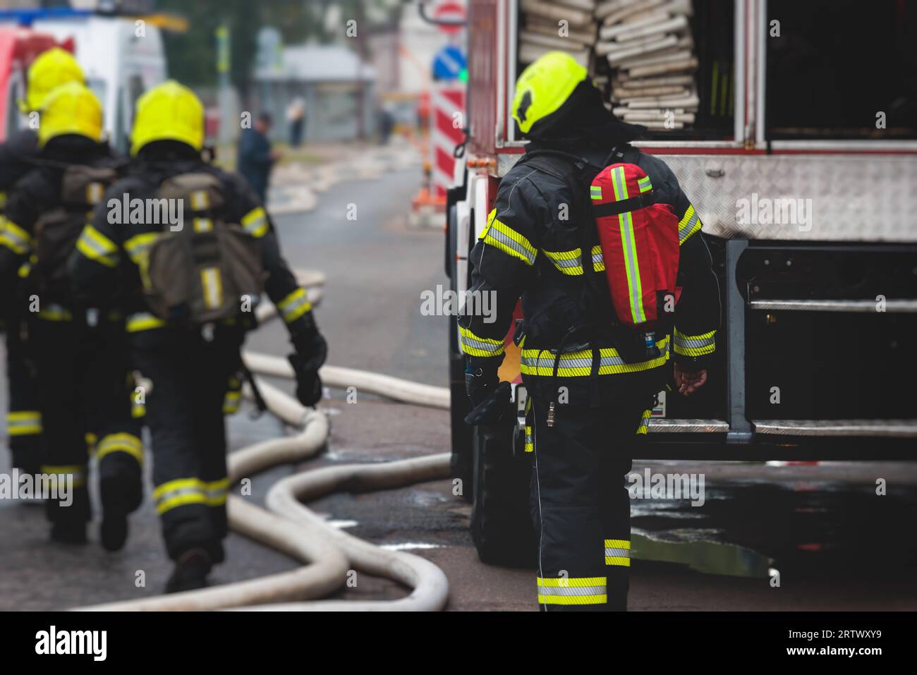 Group of fire men in protective uniform during fire fighting operation ...