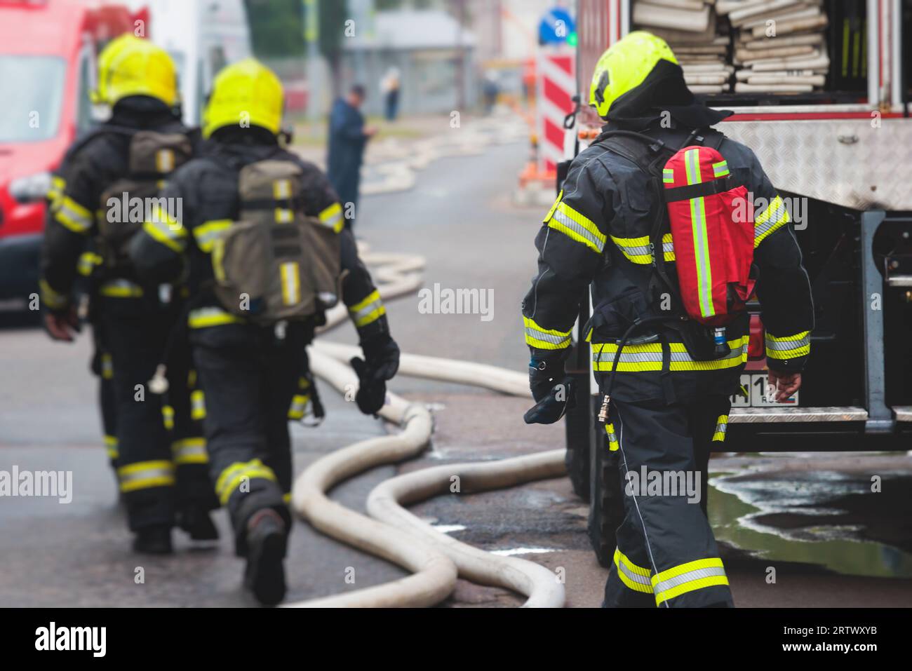 Group of fire men in protective uniform during fire fighting operation ...