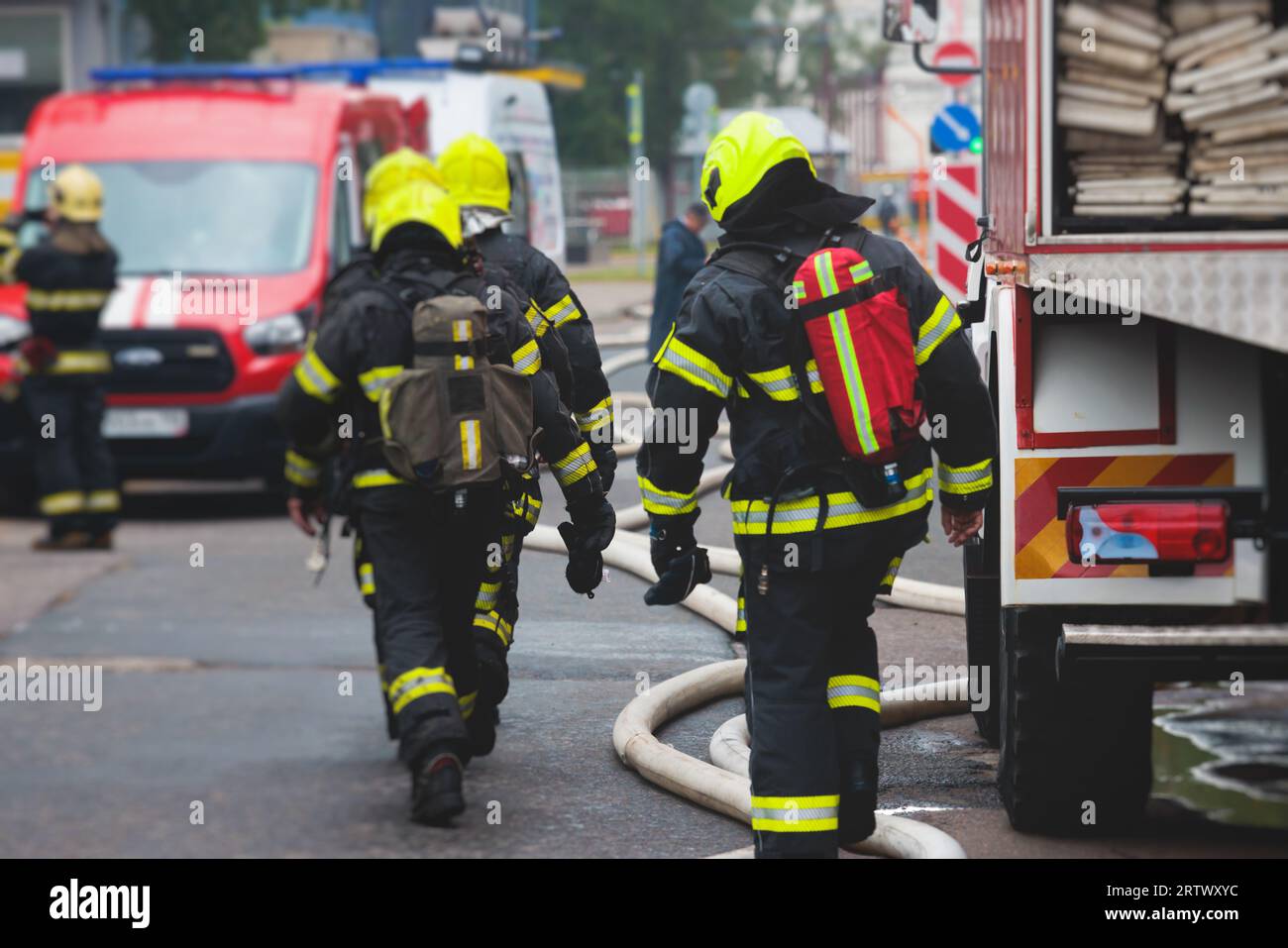 Group of fire men in protective uniform during fire fighting operation ...