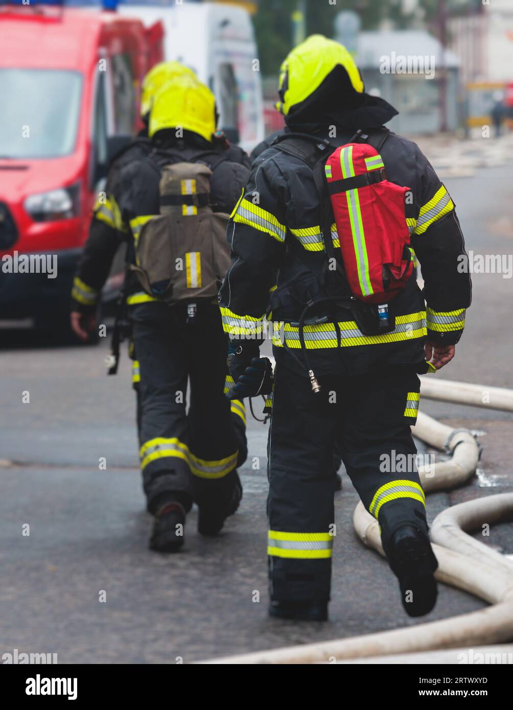 Group of fire men in protective uniform during fire fighting operation ...