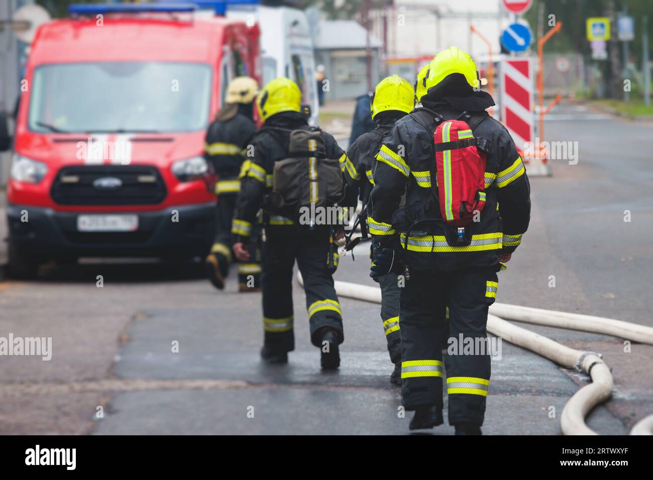 Group of fire men in protective uniform during fire fighting operation ...