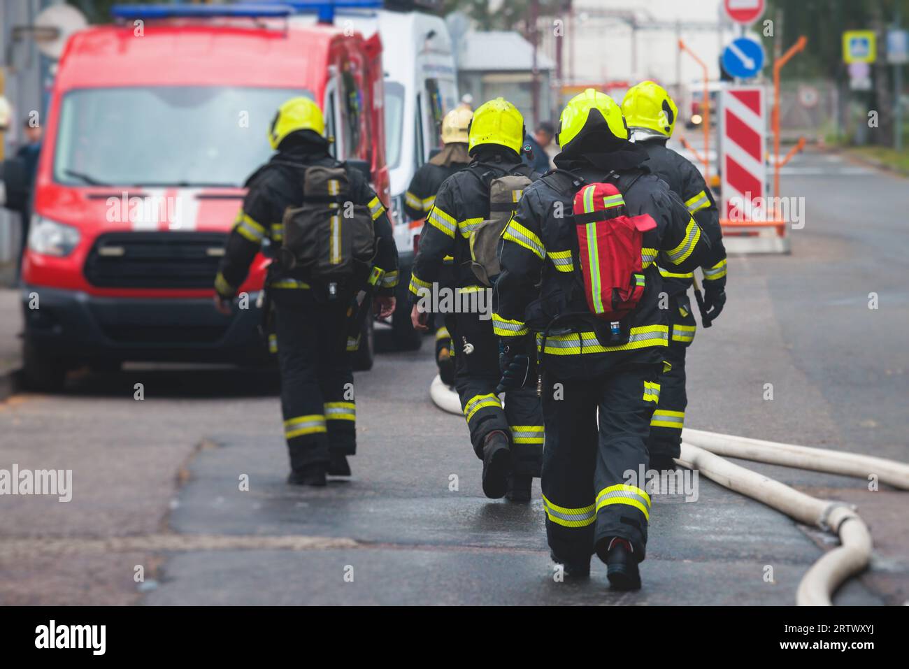 Group of fire men in protective uniform during fire fighting operation ...