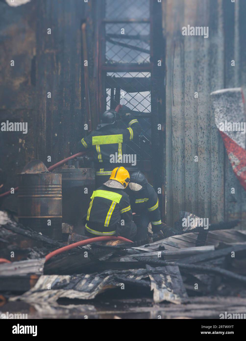 Group of fire men in protective uniform during fire fighting operation ...