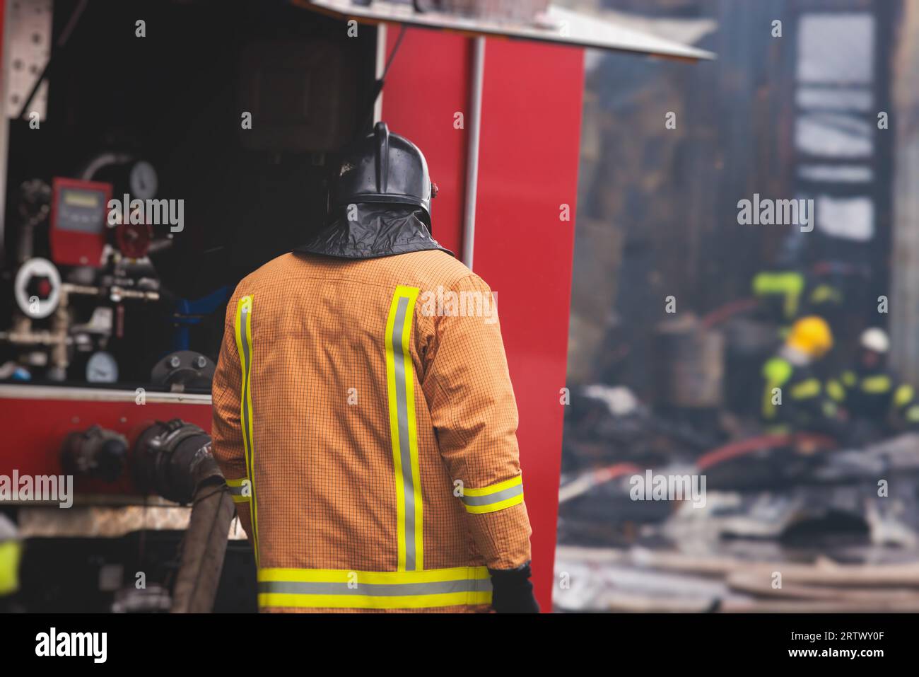 Group of fire men in protective uniform during fire fighting operation ...