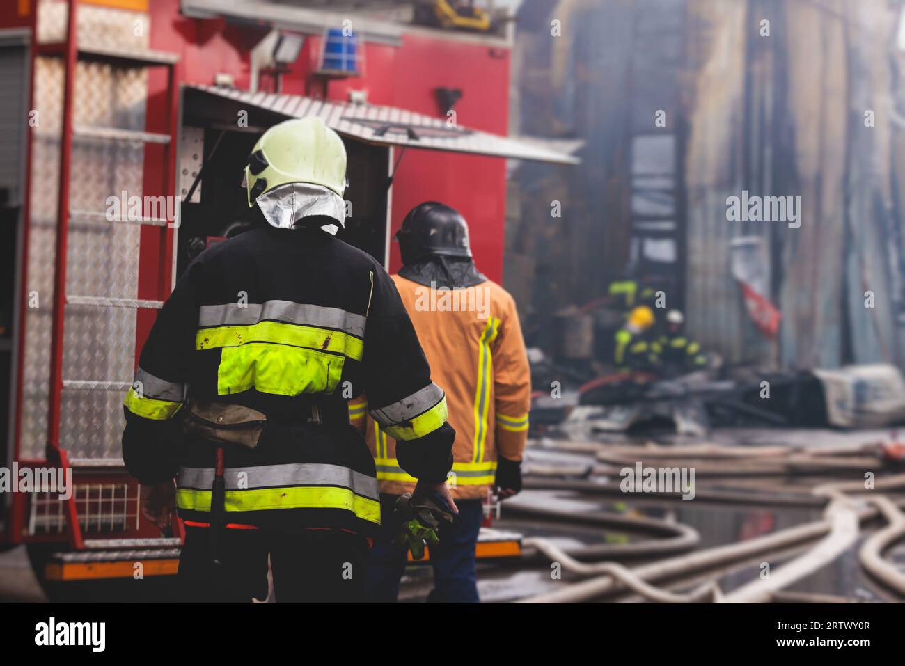 Group of fire men in protective uniform during fire fighting operation ...