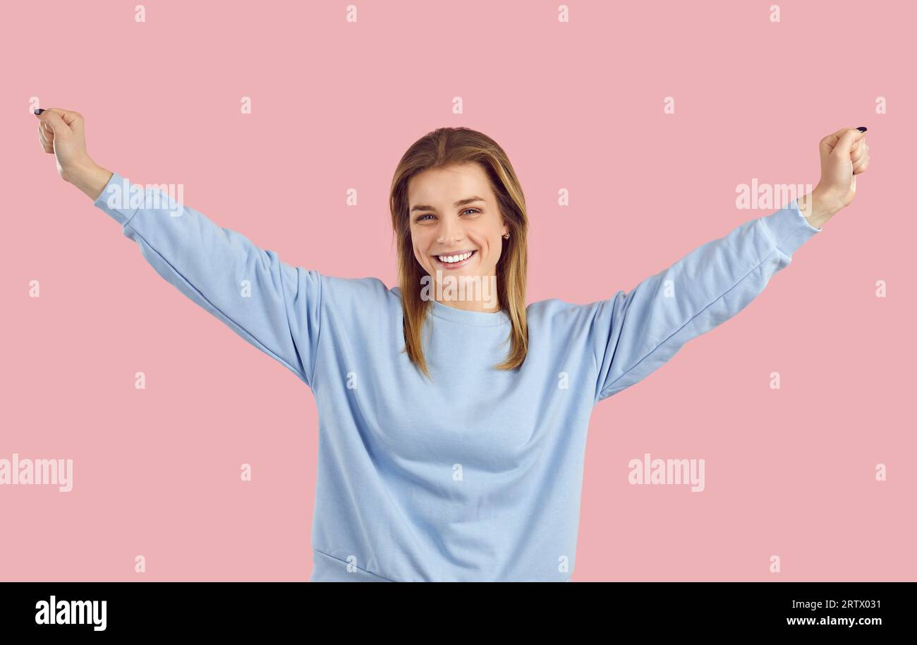 Young joyful Caucasian woman stretches arms to side wants to stretch ...