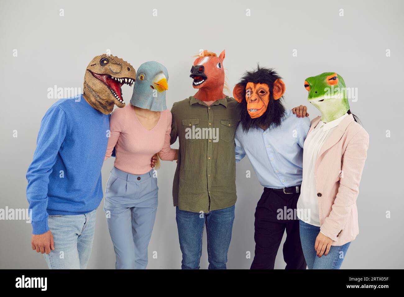 Group of strange men and women in funny carnival animal masks hugging ...