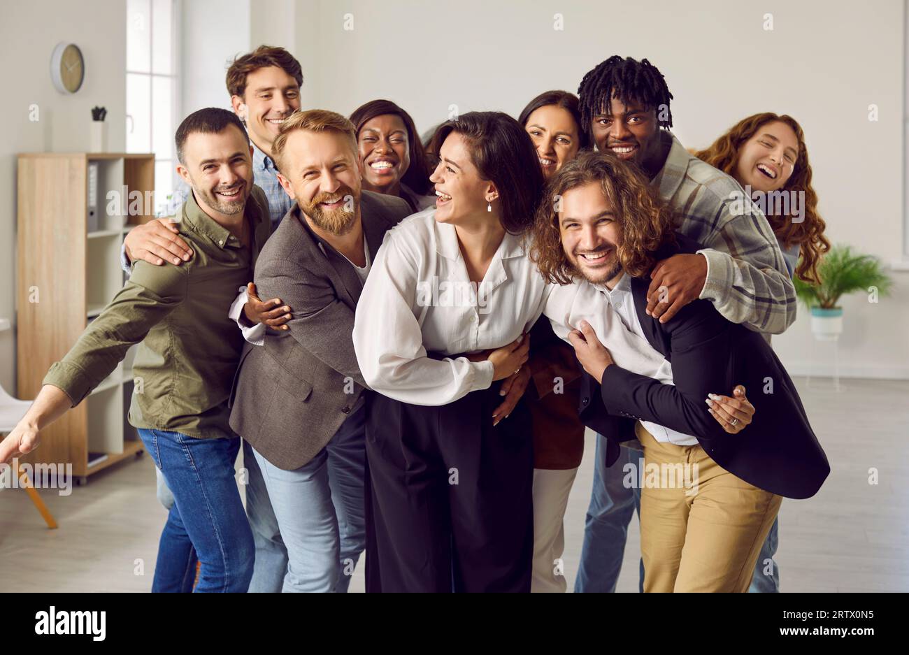 Team of cheerful diverse business colleagues and friends hugging all ...