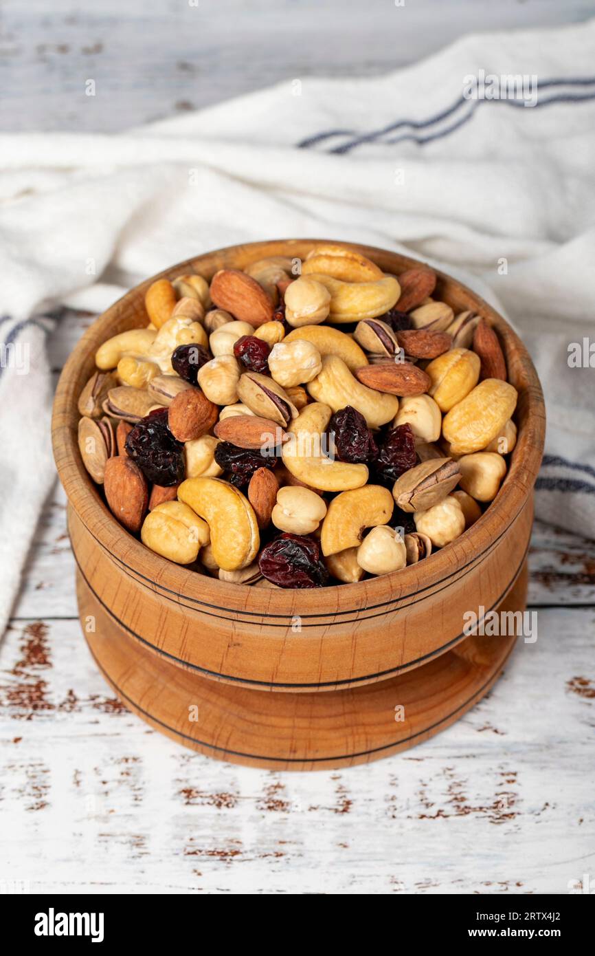 Mixed nuts in wood bowl. Nuts on white wood background. Mixed nuts ...