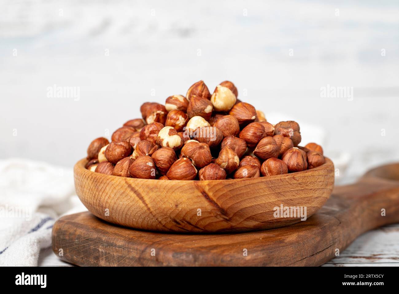 Hazelnuts in wood bowl. Hazelnut kernel on white wood background Stock Photo - Alamy