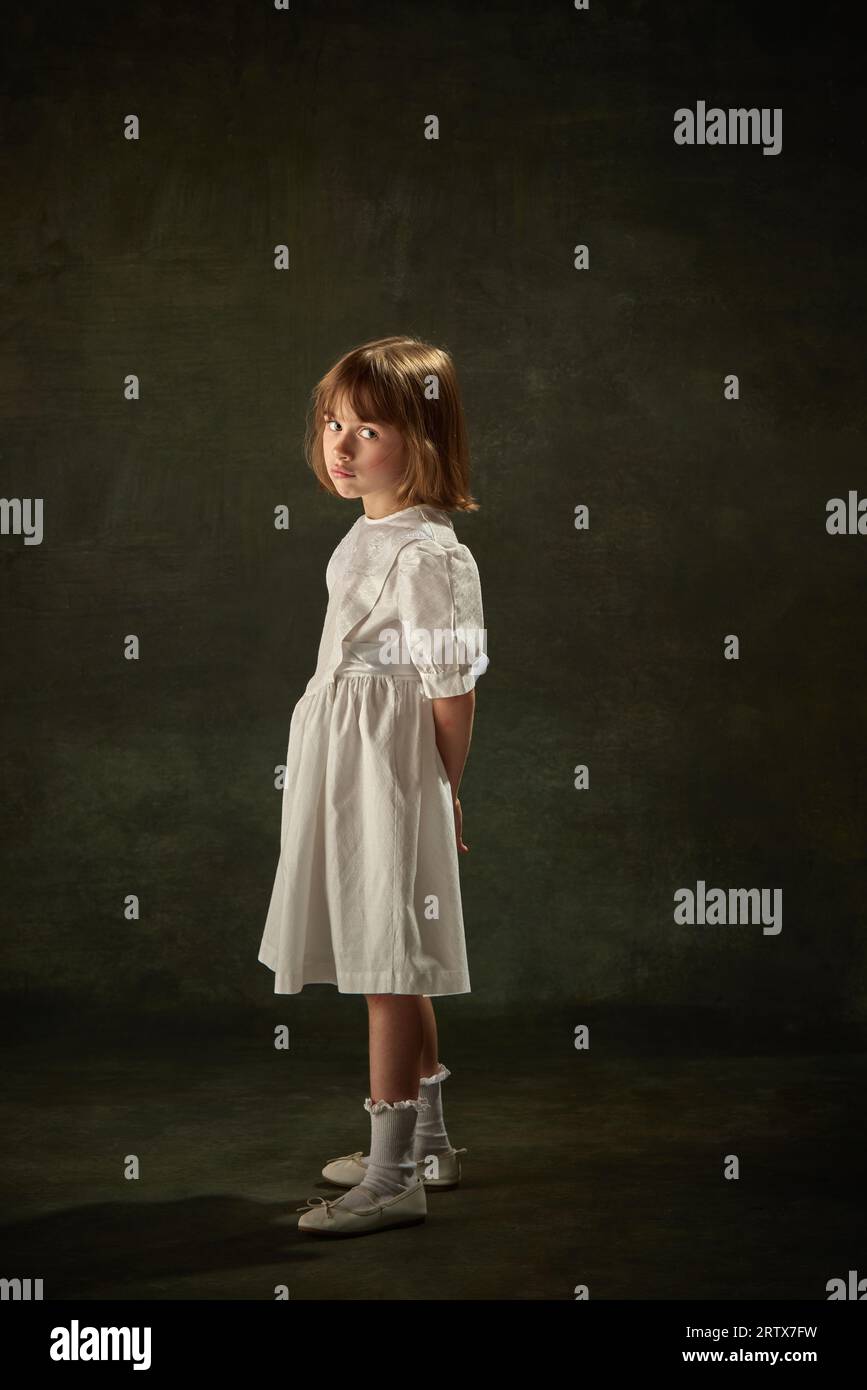 Side view portrait of lovely little girl, child in white dress against ...
