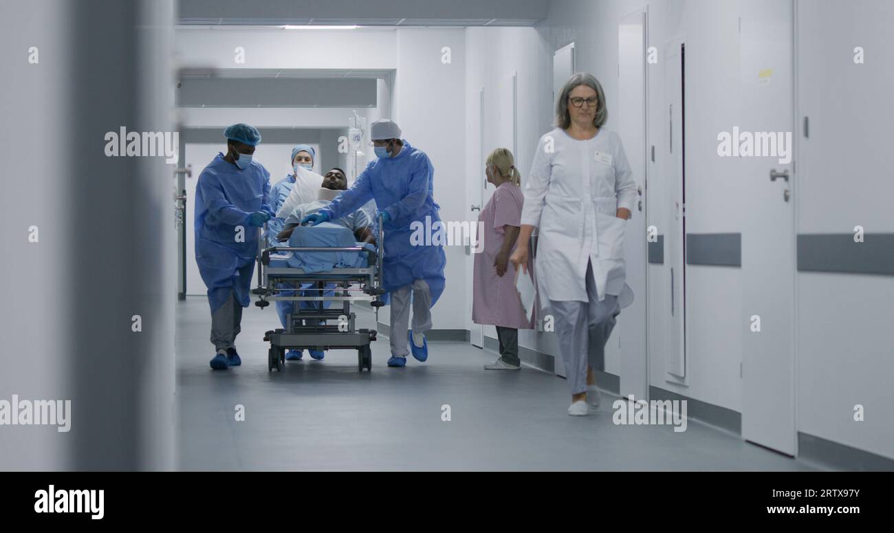 Doctors and nurses run and push gurney with seriously injured patient ...