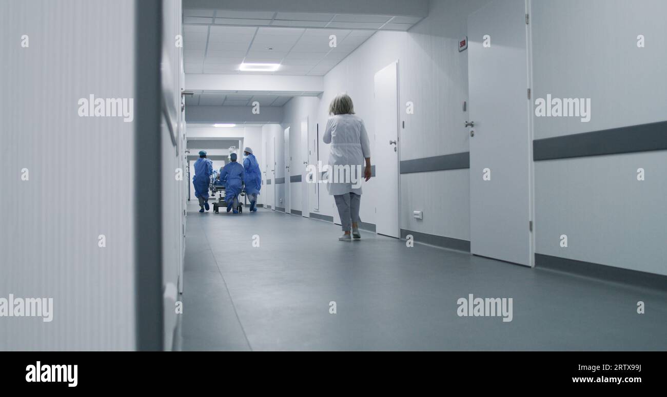 Doctors, nurses and paramedics run and push stretcher with seriously ...