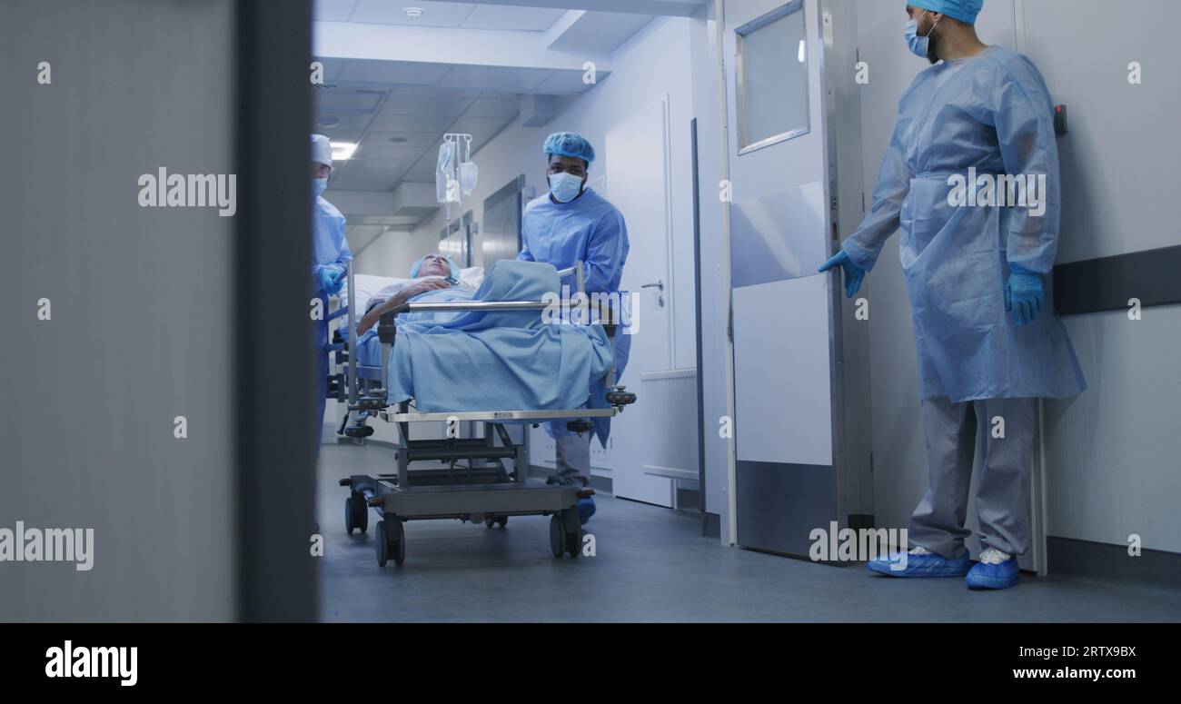Nurse and paramedic quickly open medical facility corridor doors. Multi ...