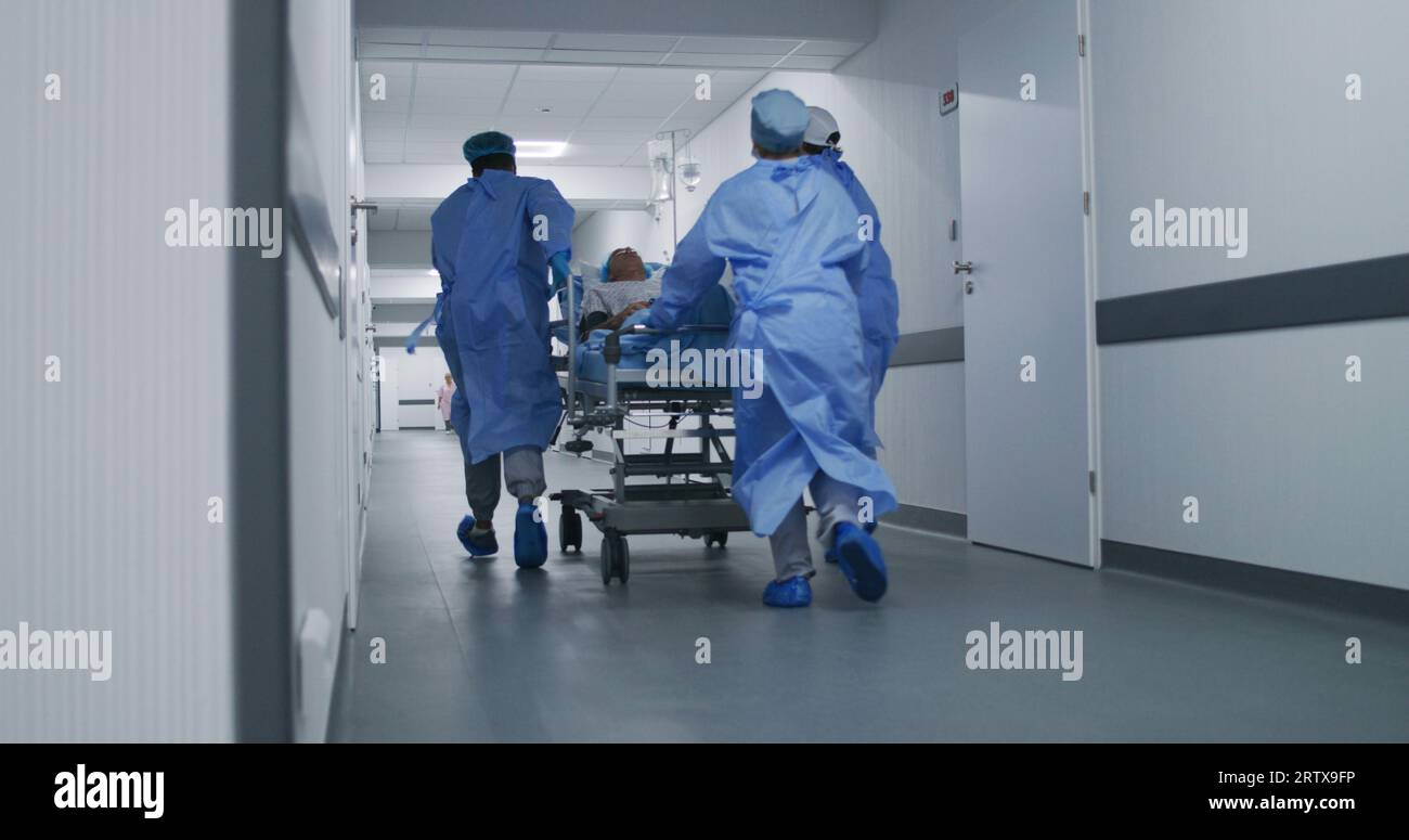 Doctors, nurses and paramedics run and push stretcher with seriously ...