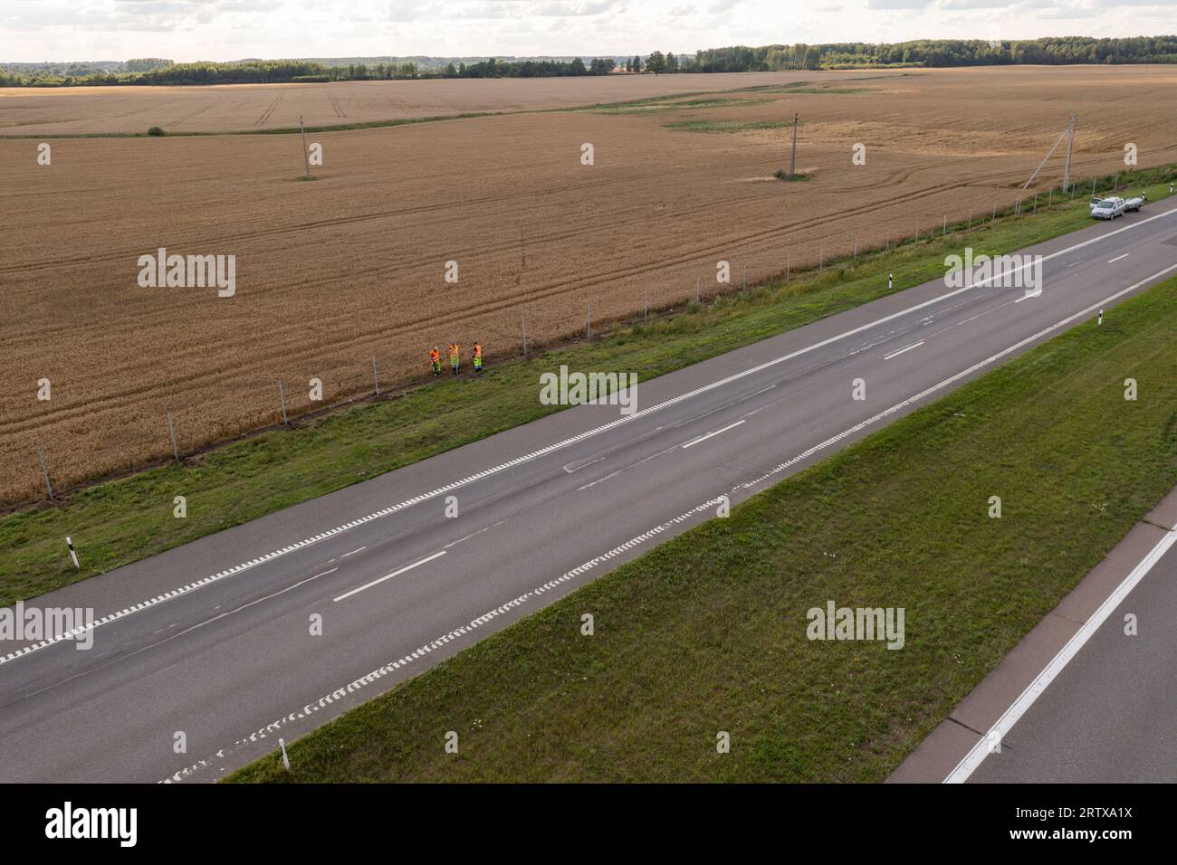 Drone photography of construction workers building a fence between a ...