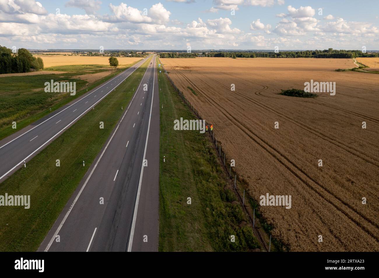 Drone photography of construction workers building a fence between a ...