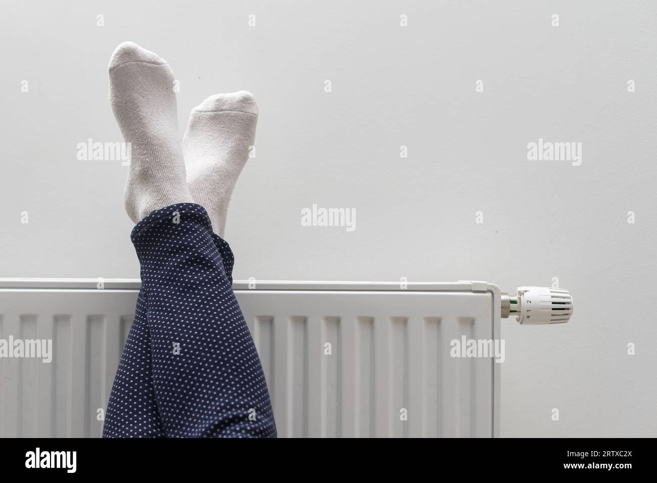 Woman Warming Up Her Feet On White Radiator At Home Stock Photo - Alamy