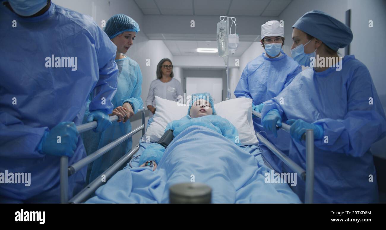 Doctors, paramedics and mom of child push stretcher with sick young ...