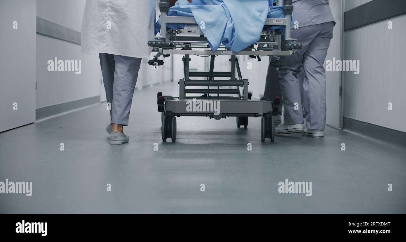 Doctors and paramedics move gurney with seriously injured patient ...