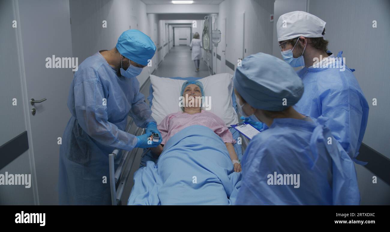 Doctors, nurses and paramedics examine ill elderly woman in medical ...