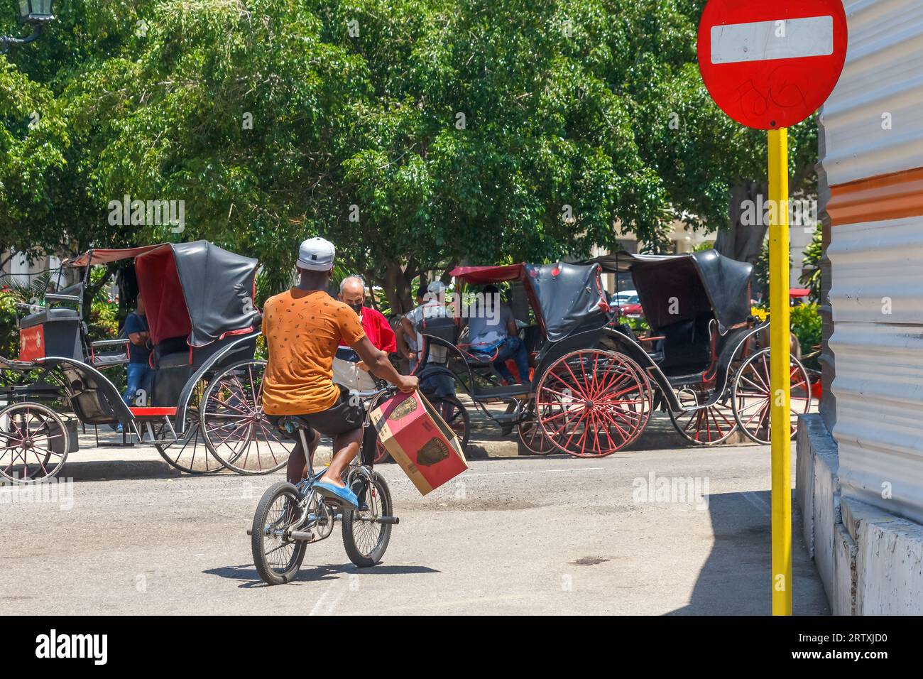 Havana, Cuba, 2023, A Cuban man rides a bicycle on a city street. He is ...