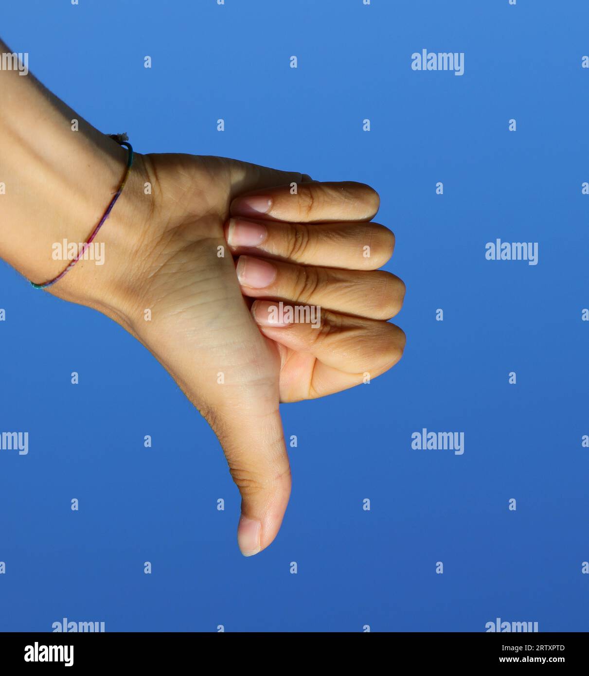 girl hand with thumb down meaning denial or failure and sky background ...