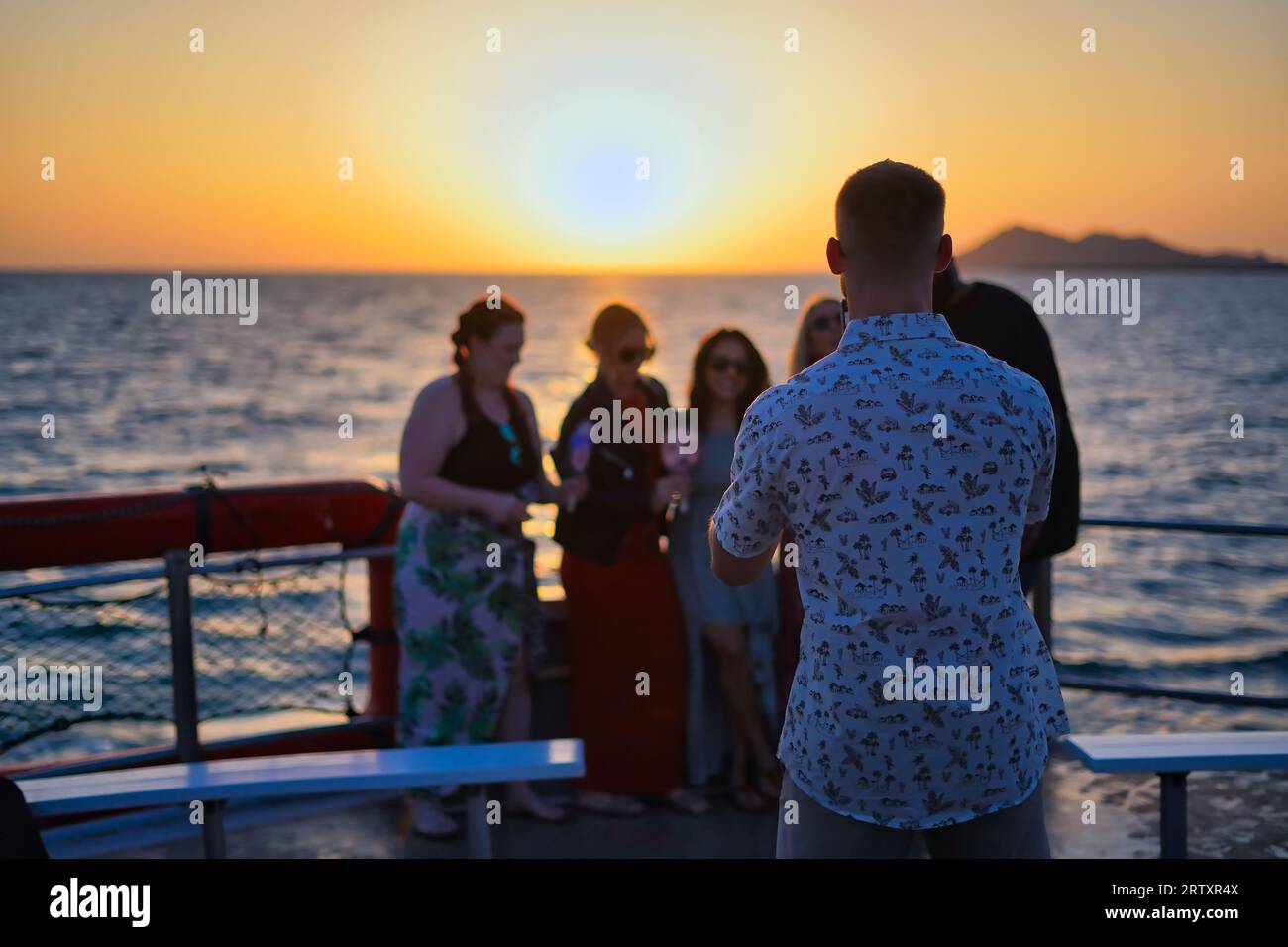 A group of people stand aboard a ship, admiring the spectacular view of ...