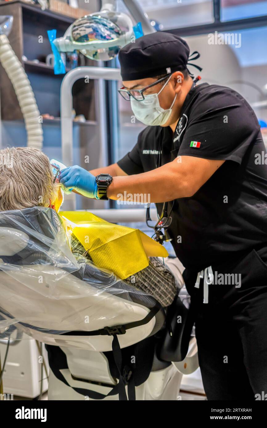 An experienced dentist is performing a medical procedure on an elderly ...