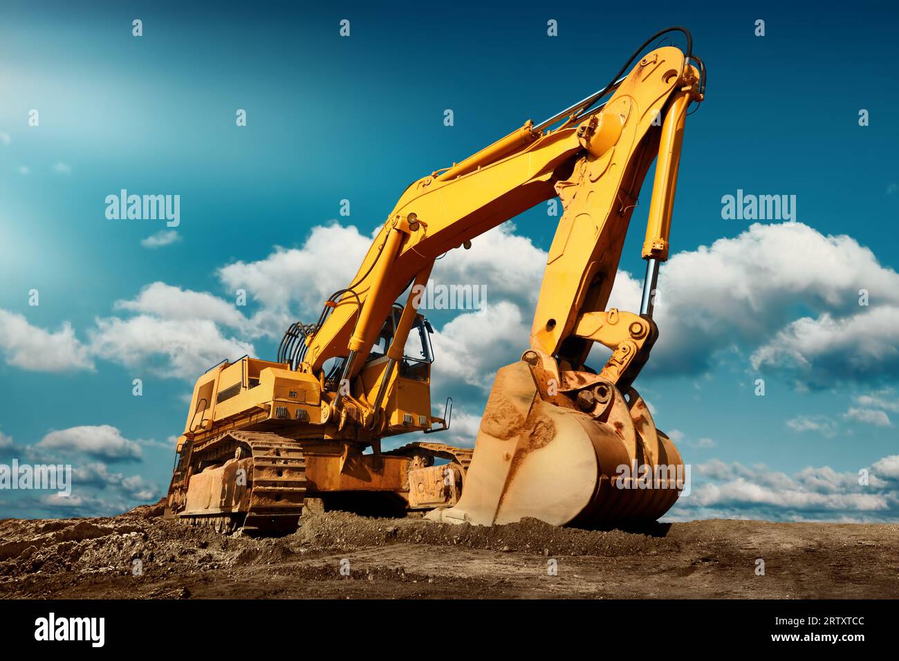 Large excavator on construction site on a sunny day with blue sky and ...