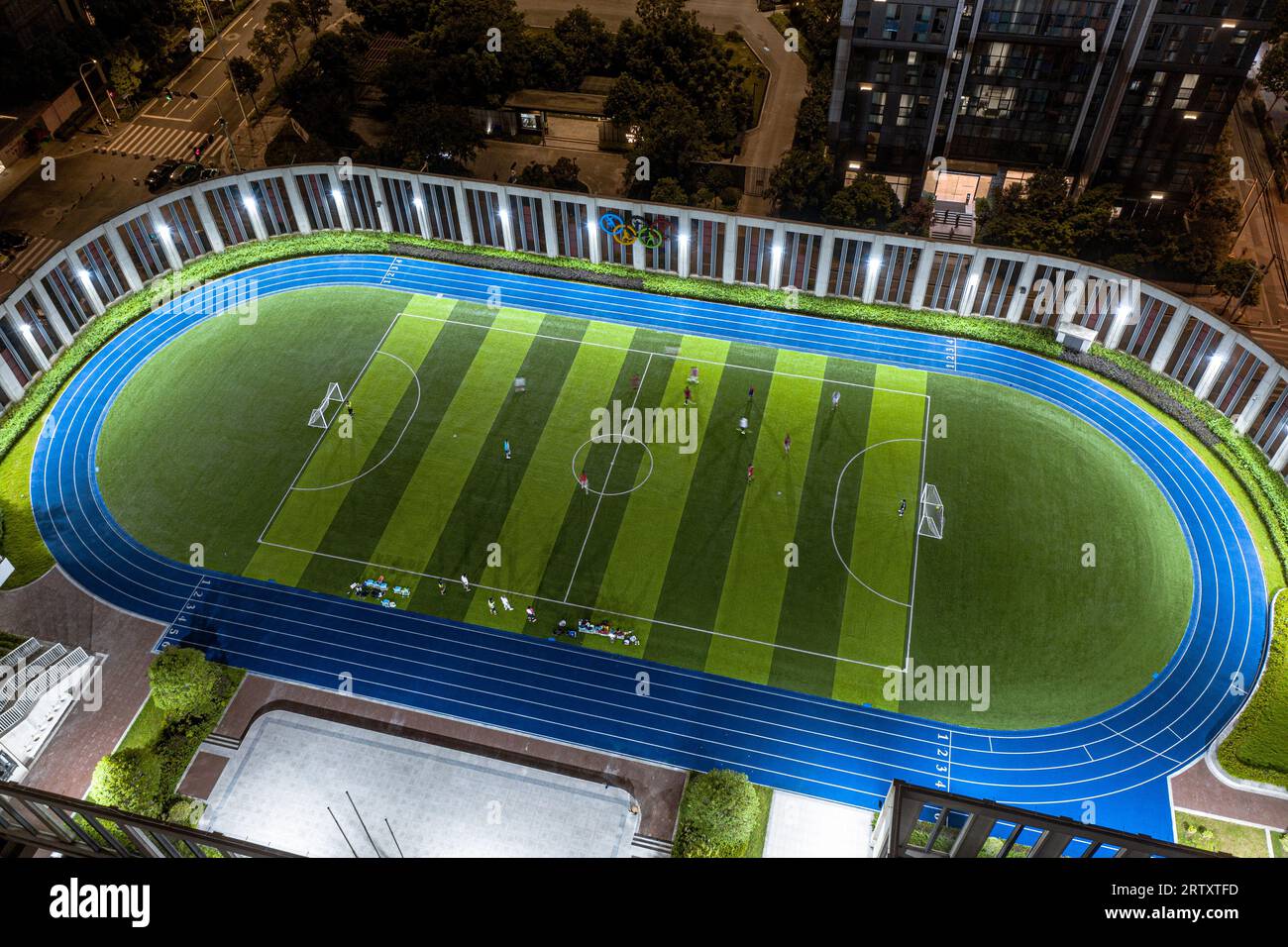 An aerial view of an illuminated soccer field on a tall building roof ...